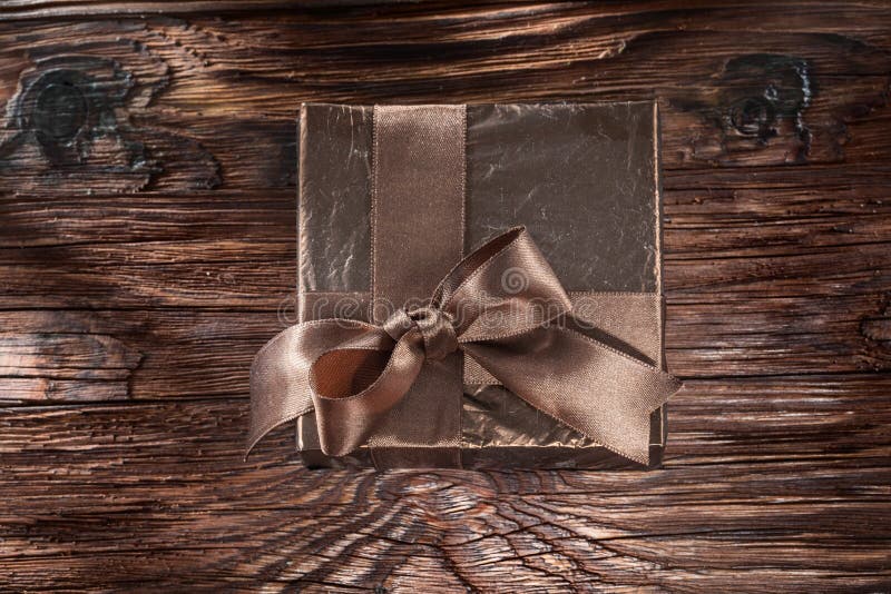 Brown Present Box with Bow on Vintage Board Stock Image - Image of ...