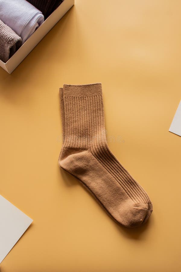 Brown Ribbed Sock Pair on Bright Yellow Surface, Highlighting Its Soft ...