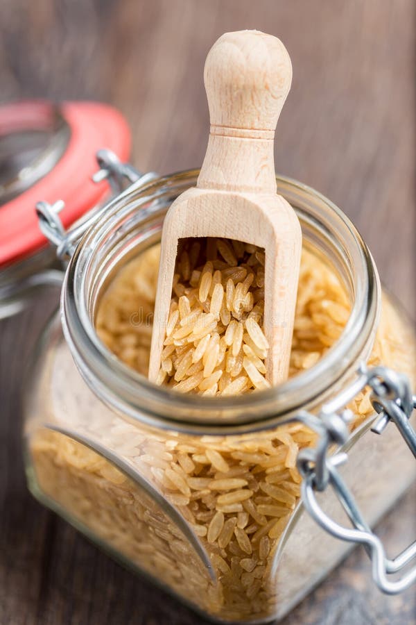 Brown Rice in a Glass Jar with Wood Spoon Stock Image - Image of spoon ...