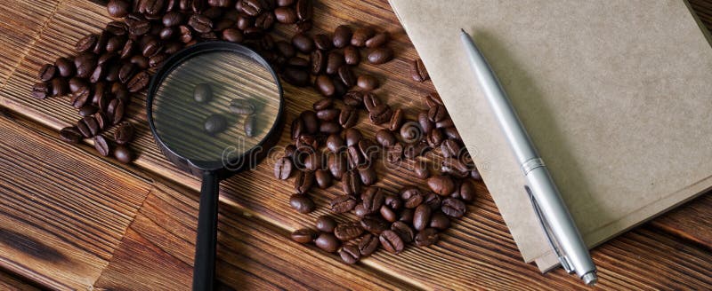 Brown Roasted Coffee Beans, Magnifying Glass, Pen and Notepad on Pine ...