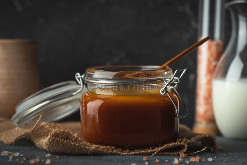 Salted Caramel in a Glass Jar on Burlap on a Black Background Stock ...