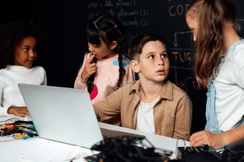 Brown Shirt Student and White Bib Student Watch Laptop and Discuss ...