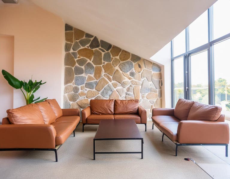 Brown Sofas Against Stone Tiles Cladding Wall in Room with High Ceiling ...