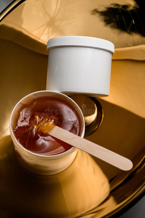 Brown Sugaring Paste or Wax Honey in a Plastic Container with a Wooden ... Brown Sugaring Paste or Wax Honey in a Plastic Container with a Wooden ...