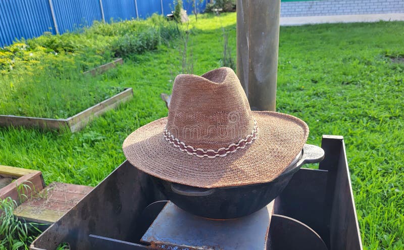 A Brown Summer Men S Hat Lying on a Cauldron Standing on an Iron Summer ...