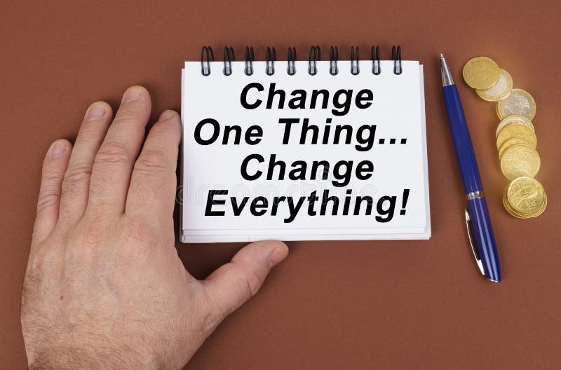 On a Brown Surface are Coins, a Pen and a Notepad with the Inscription ...