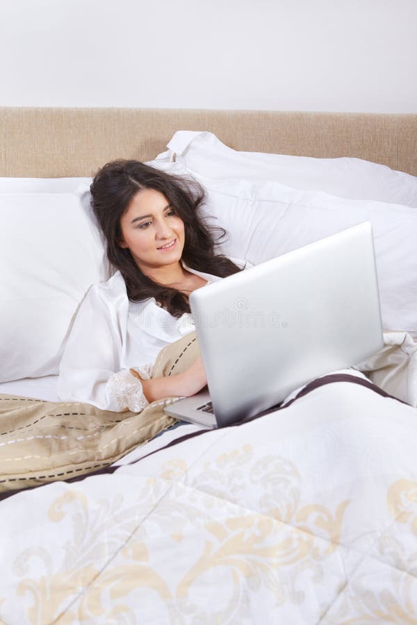 Browsing internet on bed stock image. Image of people - 28671373