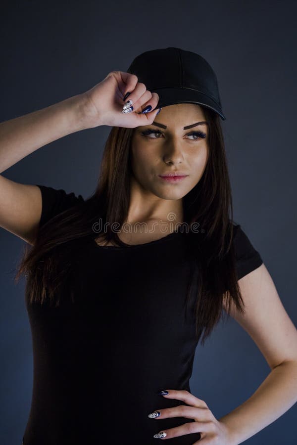 Brunette Girl Holding Her Cap while Posing Studio Stock Photo - Image ...