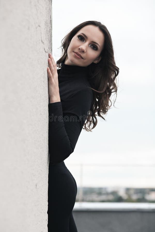 Brunette girl near wall stock photo. Image of catsuit - 27479282