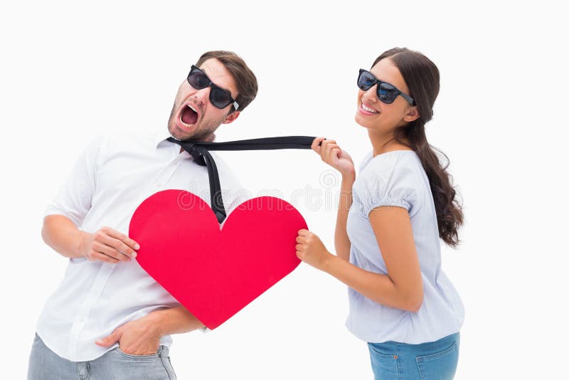 Brunette Pulling Her Boyfriend by the Tie Holding Heart Stock Photo ...