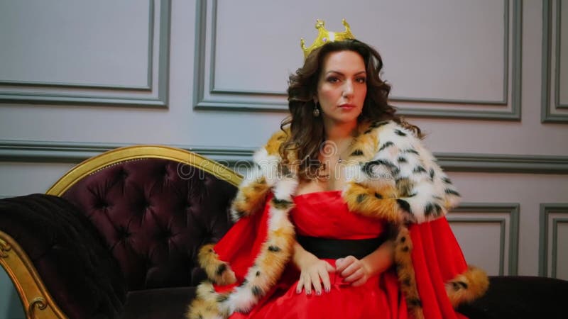 Brunette in Red Clothes with Fur and Crown Sits on Stock Footage ...