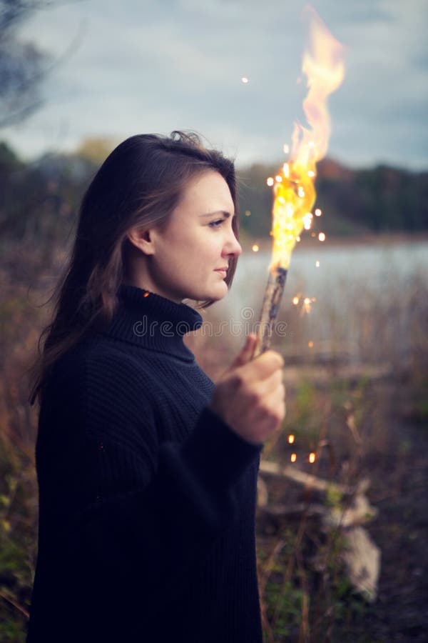 Brunette Woman in the Dark Holding a Torch Stock Photo - Image of tree ...