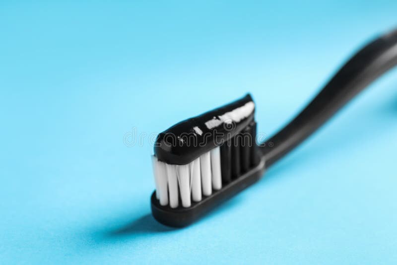 Brush with Charcoal Toothpaste on Light Blue Background, Closeup Stock ...