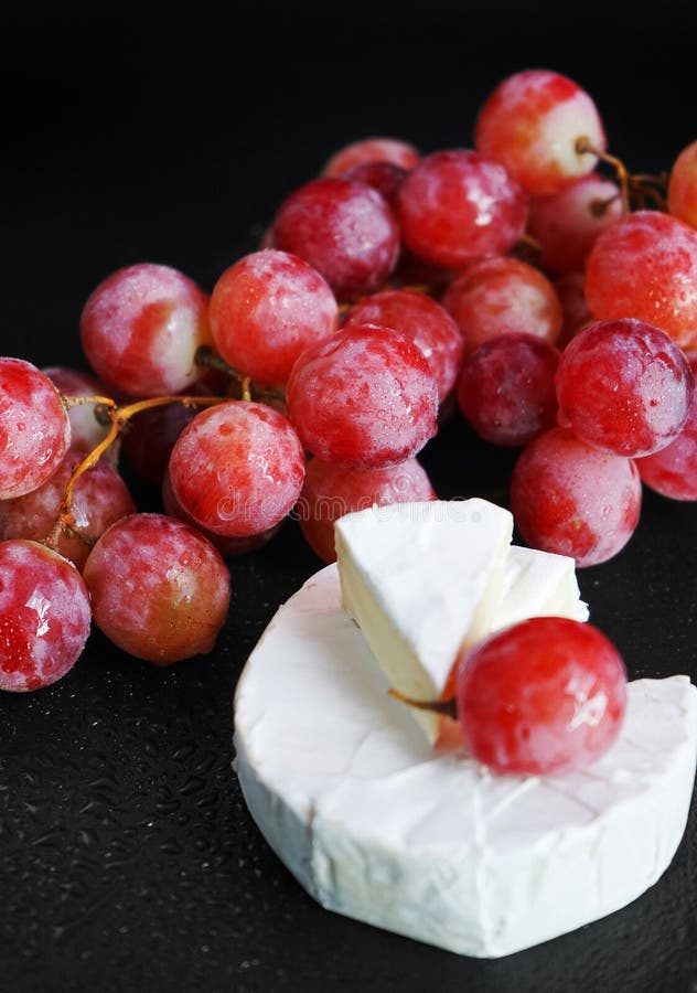 Brush of Large Pink Grapes Next To Brie Cheese Stock Image - Image of ...