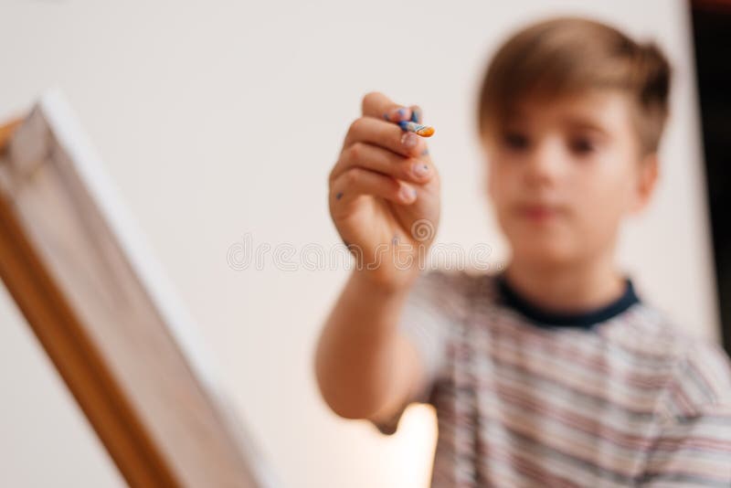 Brush with Paints in the Hands of a Boy while Drawing on Canvas Stock ...