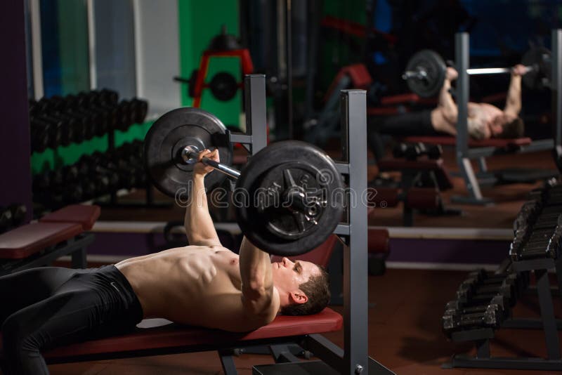 Brutal Athletic Man Pumping Up Muscles on Bench Press. Stock Image ...