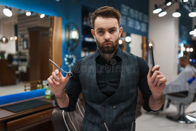 Brutal Barber Master with Scissors and a Comb in His Hands. Stock Photo ...