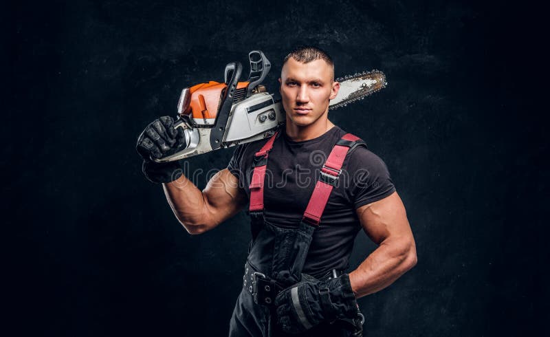 Brutal Logger Posing with a Chainsaw on His Shoulder and Looking at a ...