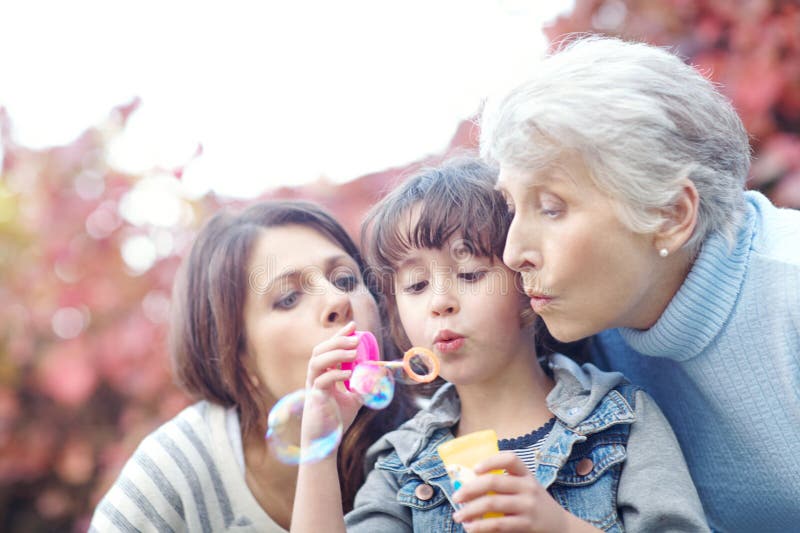 Bubble Fun. a Three Generational Family Blowing Bubbles Together. Stock ...