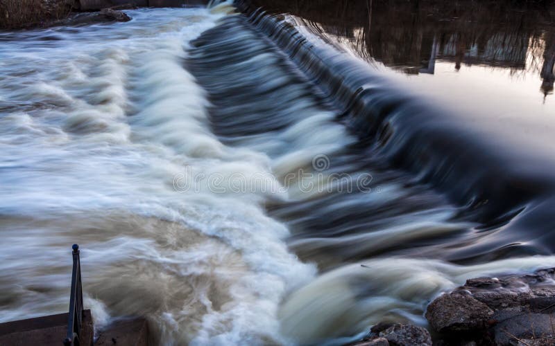 A Bubbling River with a Rapid and Reflection of Buildings in Early ...