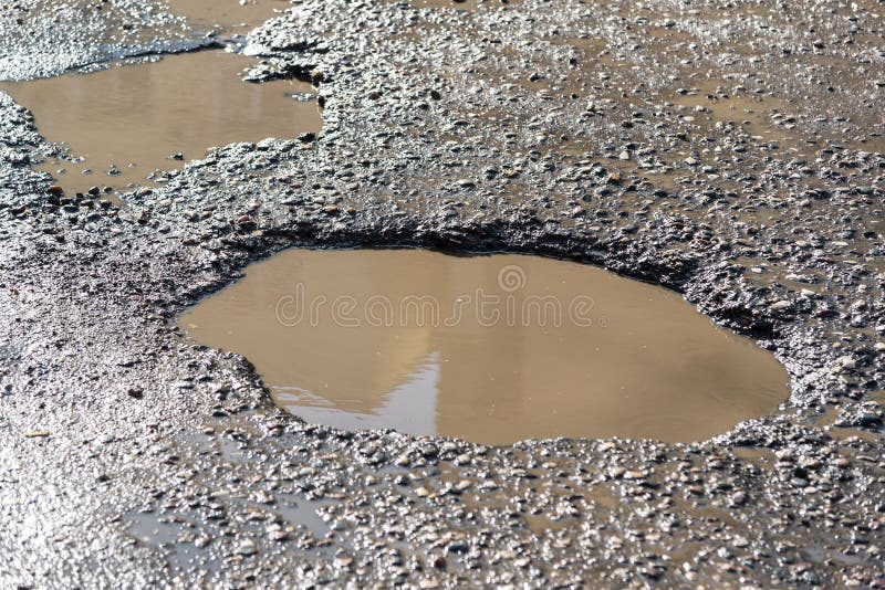 Buche Sulla Strada Asfaltata Riempita Di Acqua Immagine Stock ...