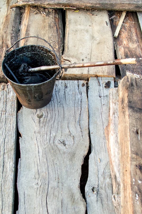 A Bucket of Black Tar Boils on the Fire for Use in Repair and ...