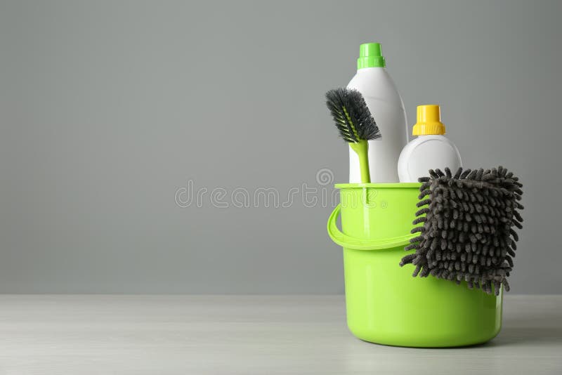 Bucket with Cleaning Products and Tools on Grey Table. Space for Text ...