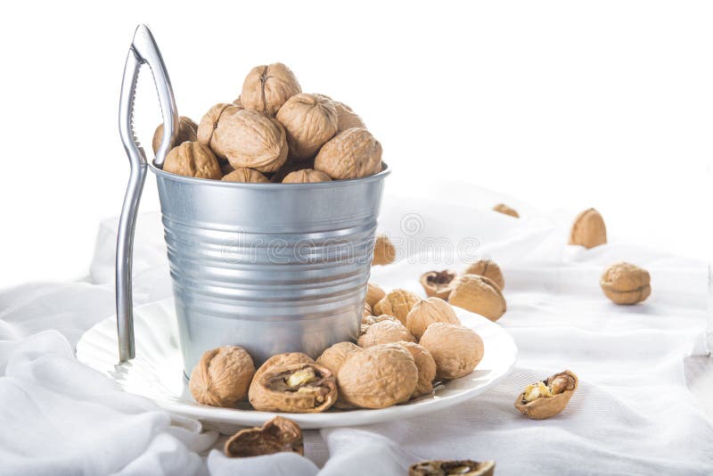 Bucket Full of Walnuts with a Nutcracker on a White Background Stock ...