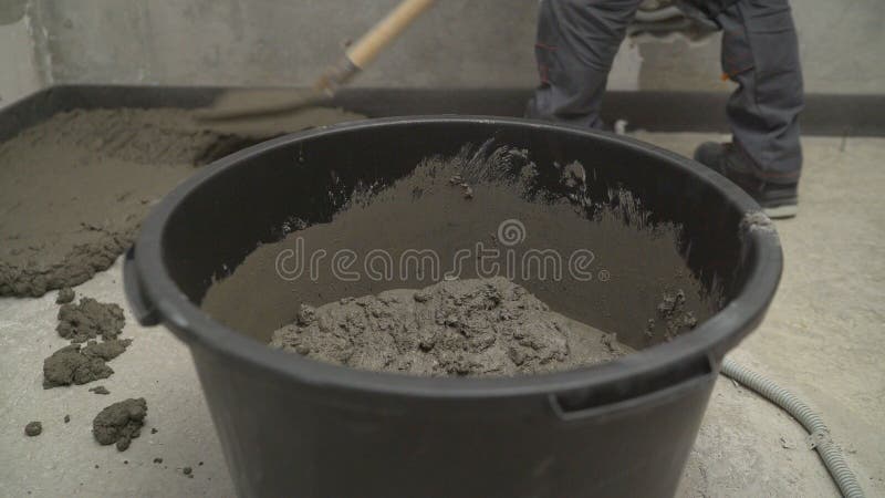 Black Bucket with Mortar for Filling the Floor. Bucket with Mortar at ...