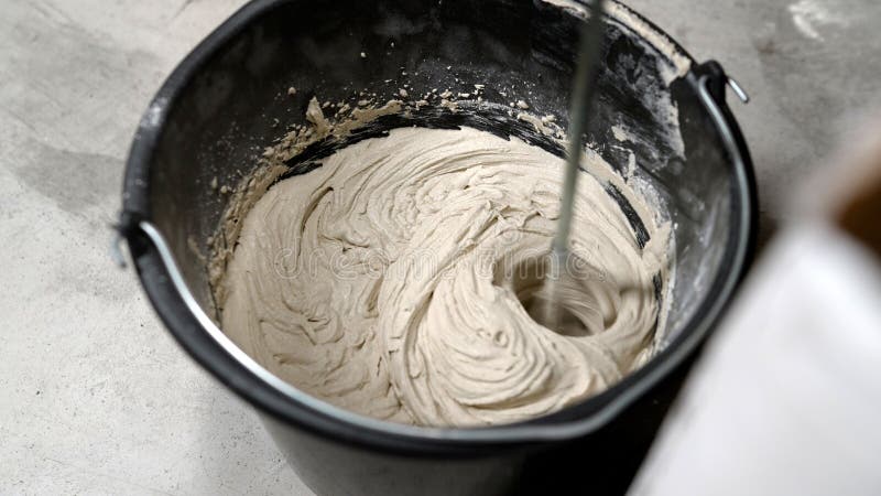 A Bucket with a Solution is Mixed with a Construction Mixer. we Mix the ...