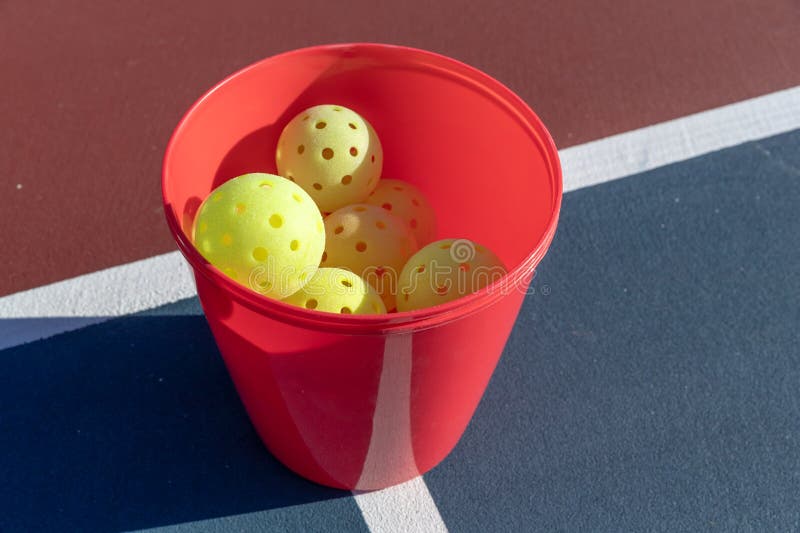 Bucket of Yellow Pickleballs on Court Ready for Practice Session. Stock ...