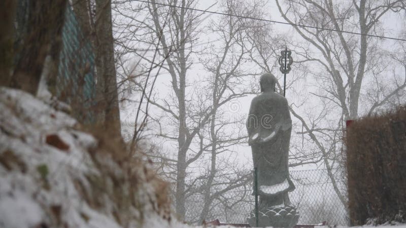 Buddhist Monk Statue in Heavy Snowfall, Back View, Low Angle, Wide Shot ...