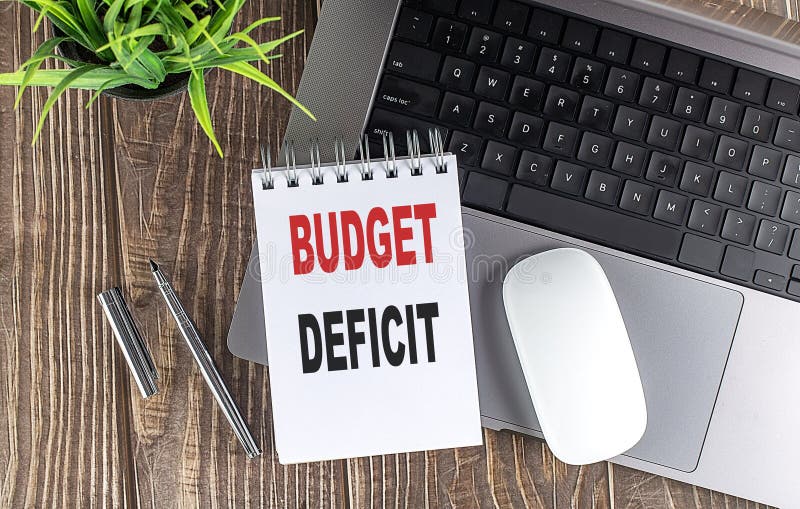 BUDGET DEFICIT Text on Notebook with Laptop, Mouse and Pen Stock Photo ...