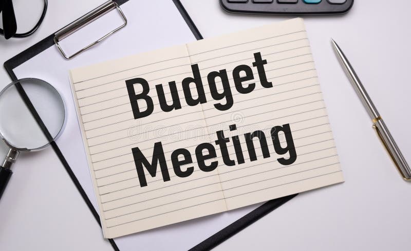 Budget Meeting Writing on a Notepad with Magnifying Glass and a Pen on ...