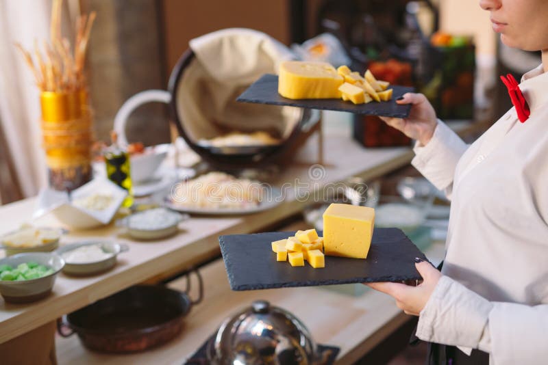 Buffet. the Waiter Holds a Plate of Sliced Cheese Stock Photo - Image ...