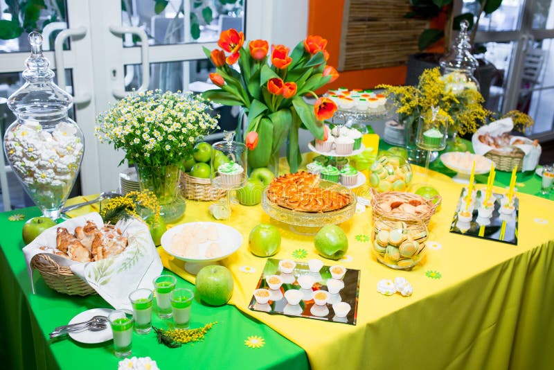 Buffet with a Yellow-green Tablecloth with Snacks, Desserts and a ...