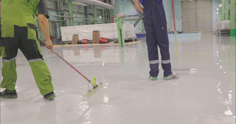 A Builder is Applying Polymer Floors Using Scraper Float. a Builder ...
