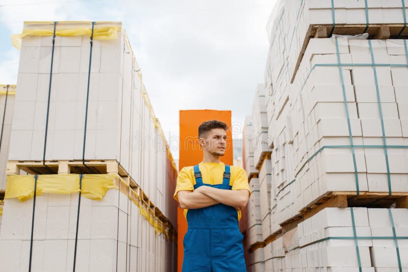 Builder between Big Pallets of Building Materials Stock Photo - Image ...