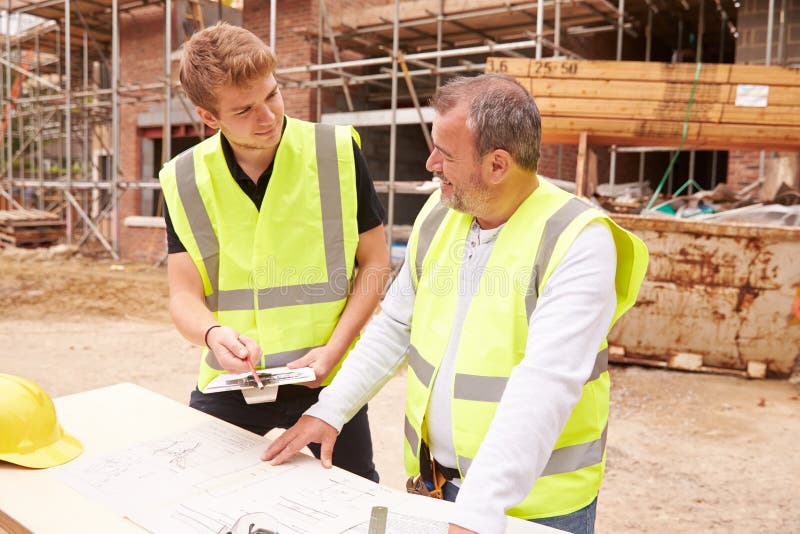 Builder and Apprentice Carrying Wood on Construction Site Stock Image ...