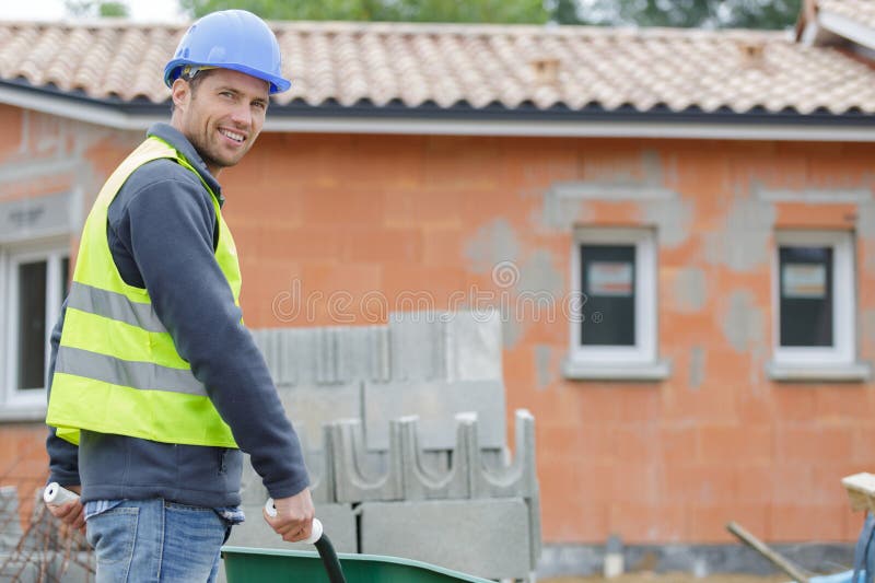 Builder Carrying Blocks on Wheelbarrow at Construction Site Stock Photo ...