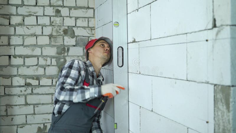 Builder Checking Evenness of Markup Lines on Block Wall with Bubble ...