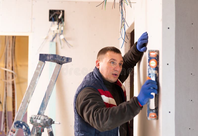 Builder Checks the Vertical of the Wall Using Level Stock Photo - Image ...