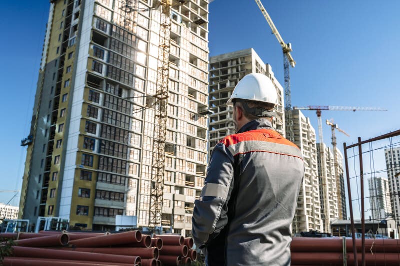 Builder at a Construction Site. Construction of a High-rise Building ...