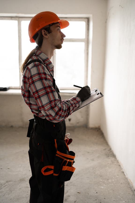 Builder at Construction Site Taking Notes on Clipboard Standing Near ...