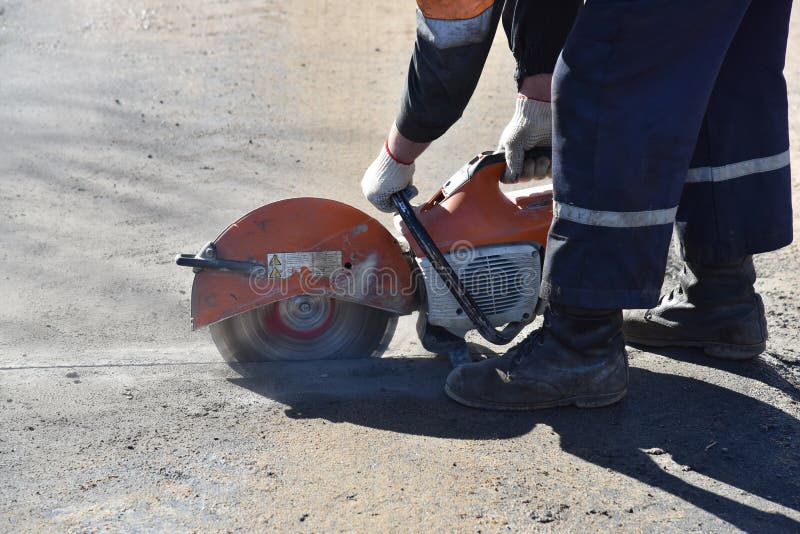 The Builder Cuts the Asphalt with a Circular Saw. Stock Photo - Image ...