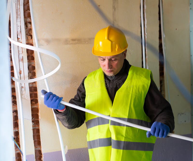 Builder Cuts Plastic Pipe with Special Interior in House Under ...