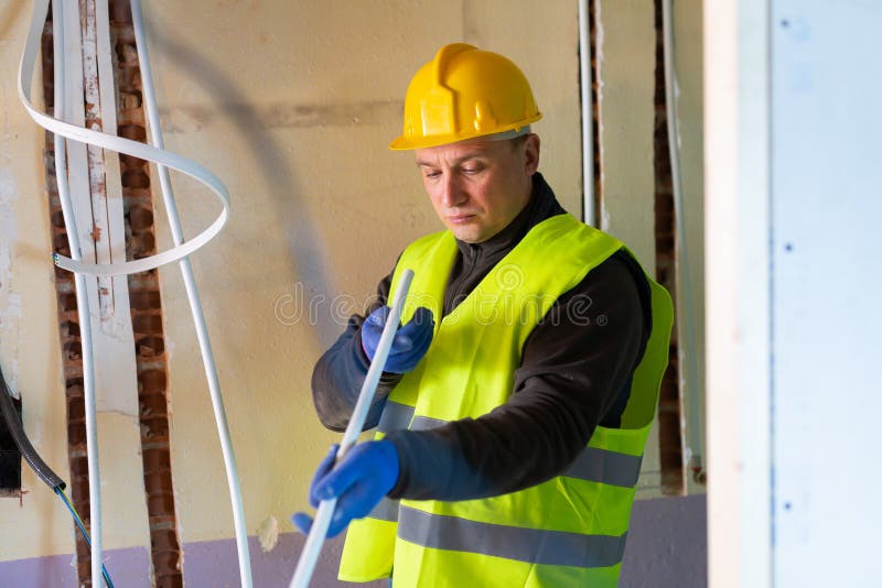 Builder Cuts Plastic Pipe with Special Interior in House Under ...