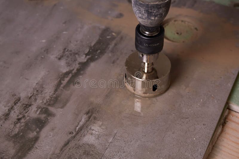 A Builder Cuts a Round Hole in a Porcelain Tile Using a Power Tool ...