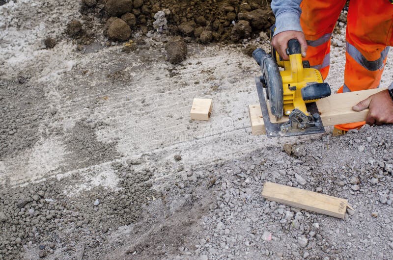 Builder Cutting Timber with a Cordless Battery-powered Circular Saw ...