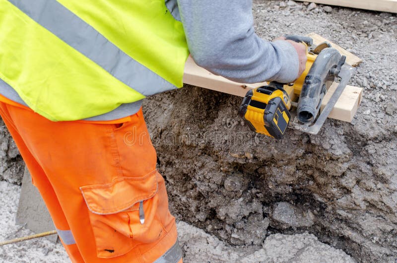 Builder Cutting Timber with a Cordless Battery-powered Circular Saw on ...